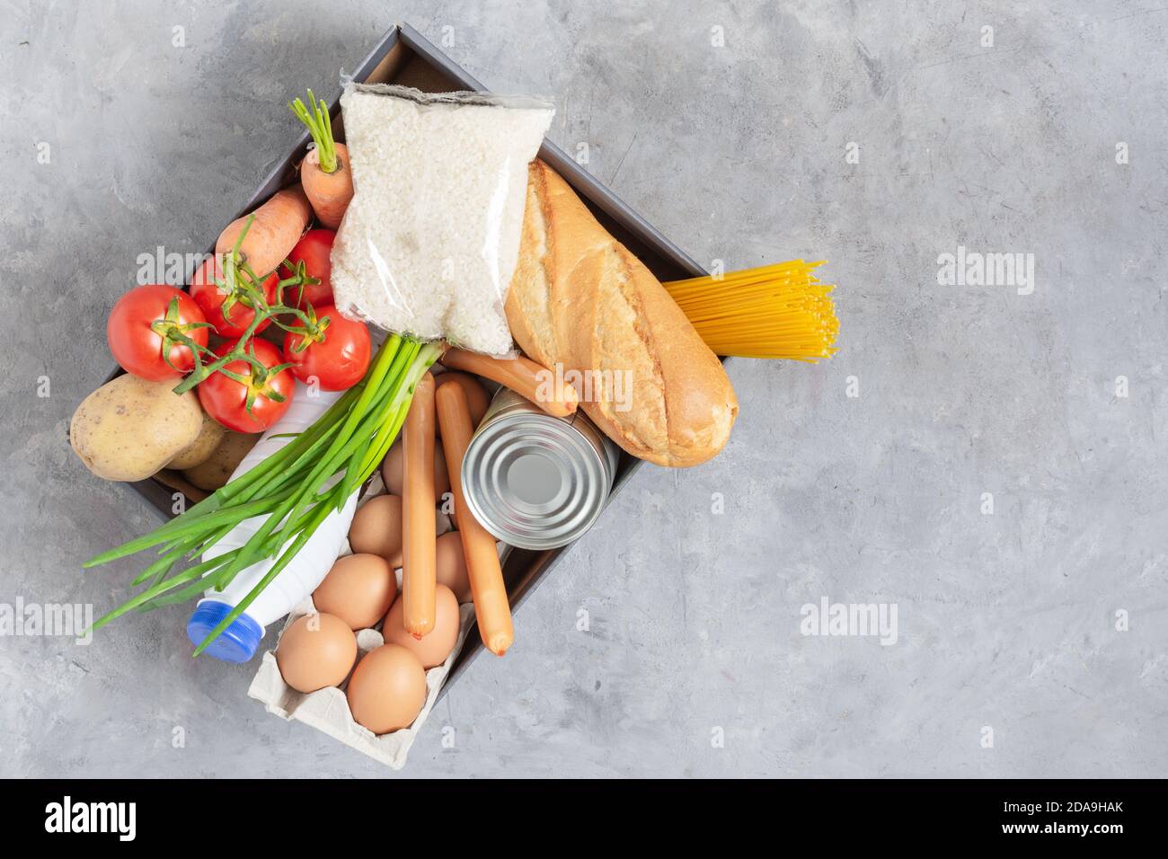 Various grocery food and fresh vegetables in a cardboard box top view ...