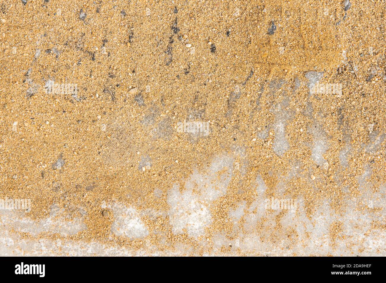 Texture of yellow sand on white ice. Sand is poured onto ice for safe ...