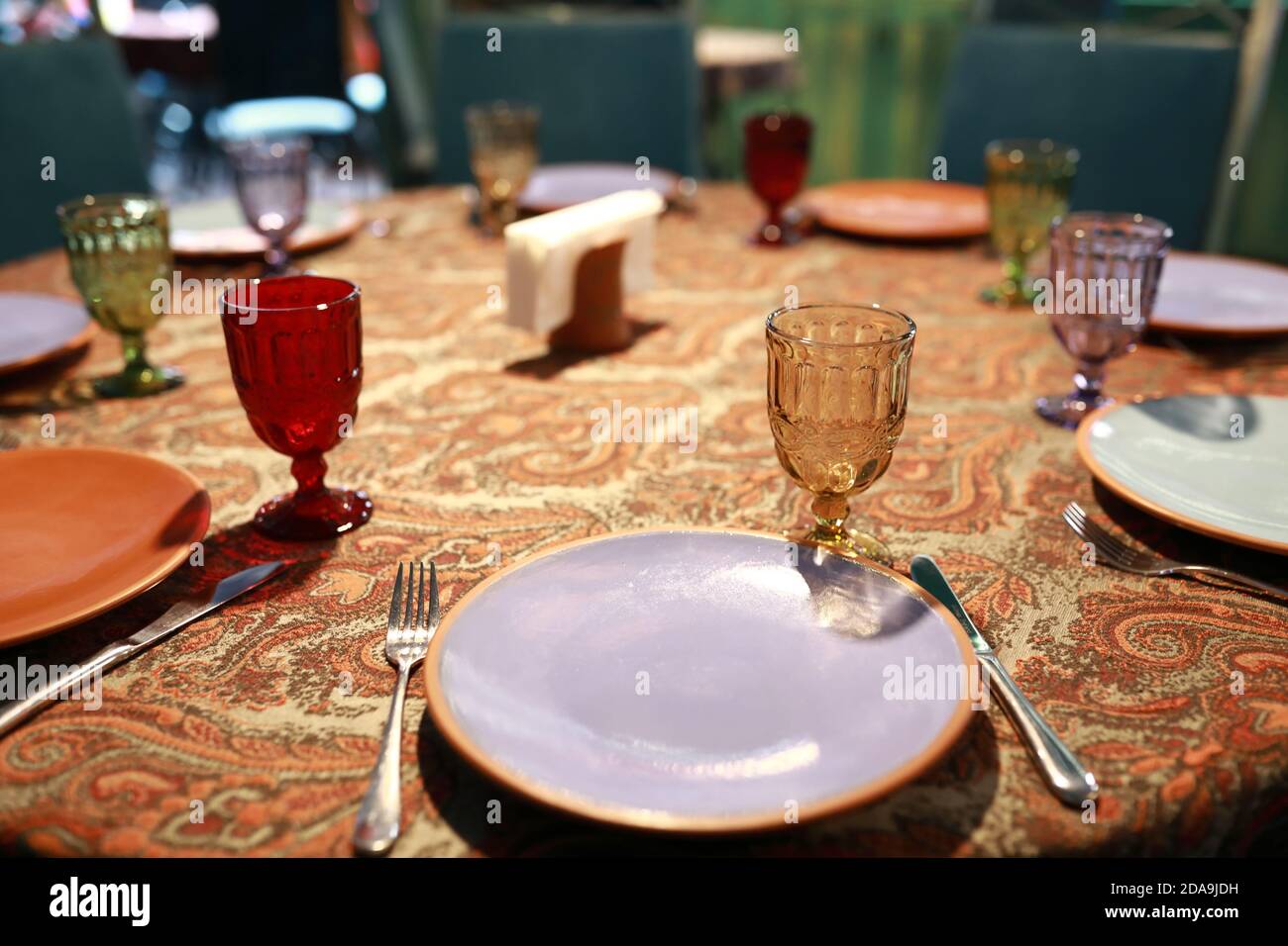 Dining table set with plates in restaurant Stock Photo - Alamy