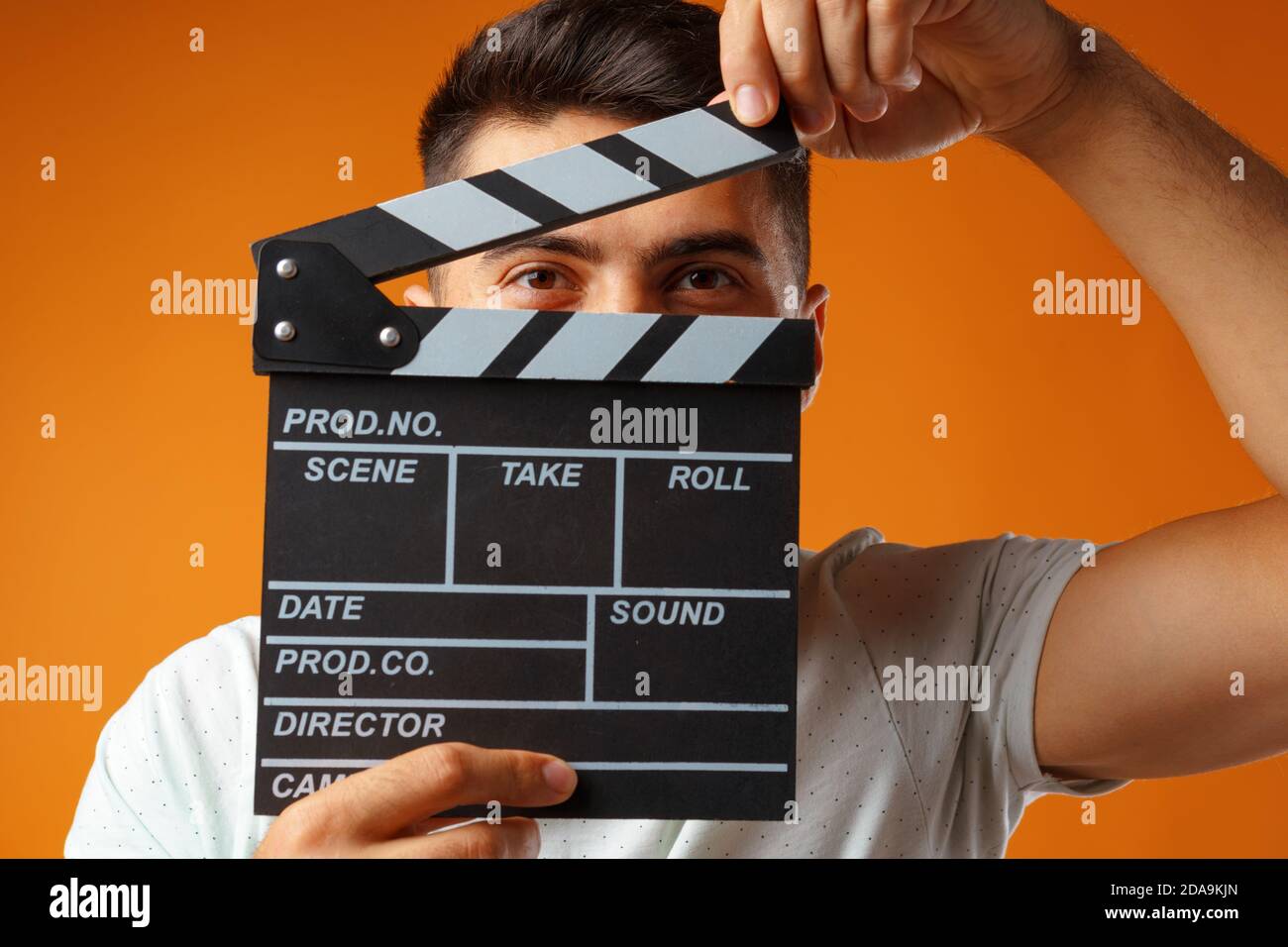 Young man holding Film clapper board against yellow background Stock ...