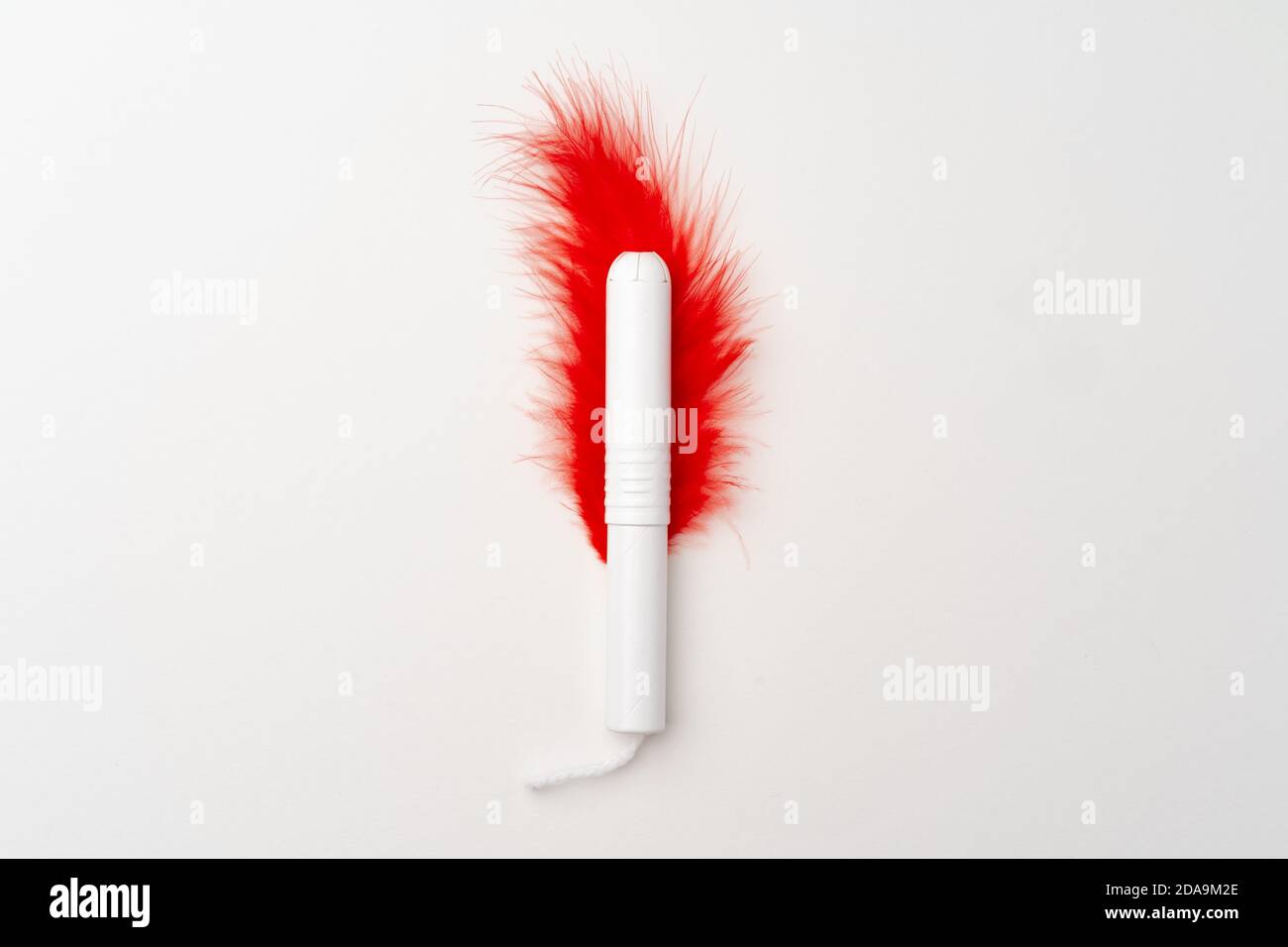 Red feather and woman medical tampon on white background Stock Photo ...