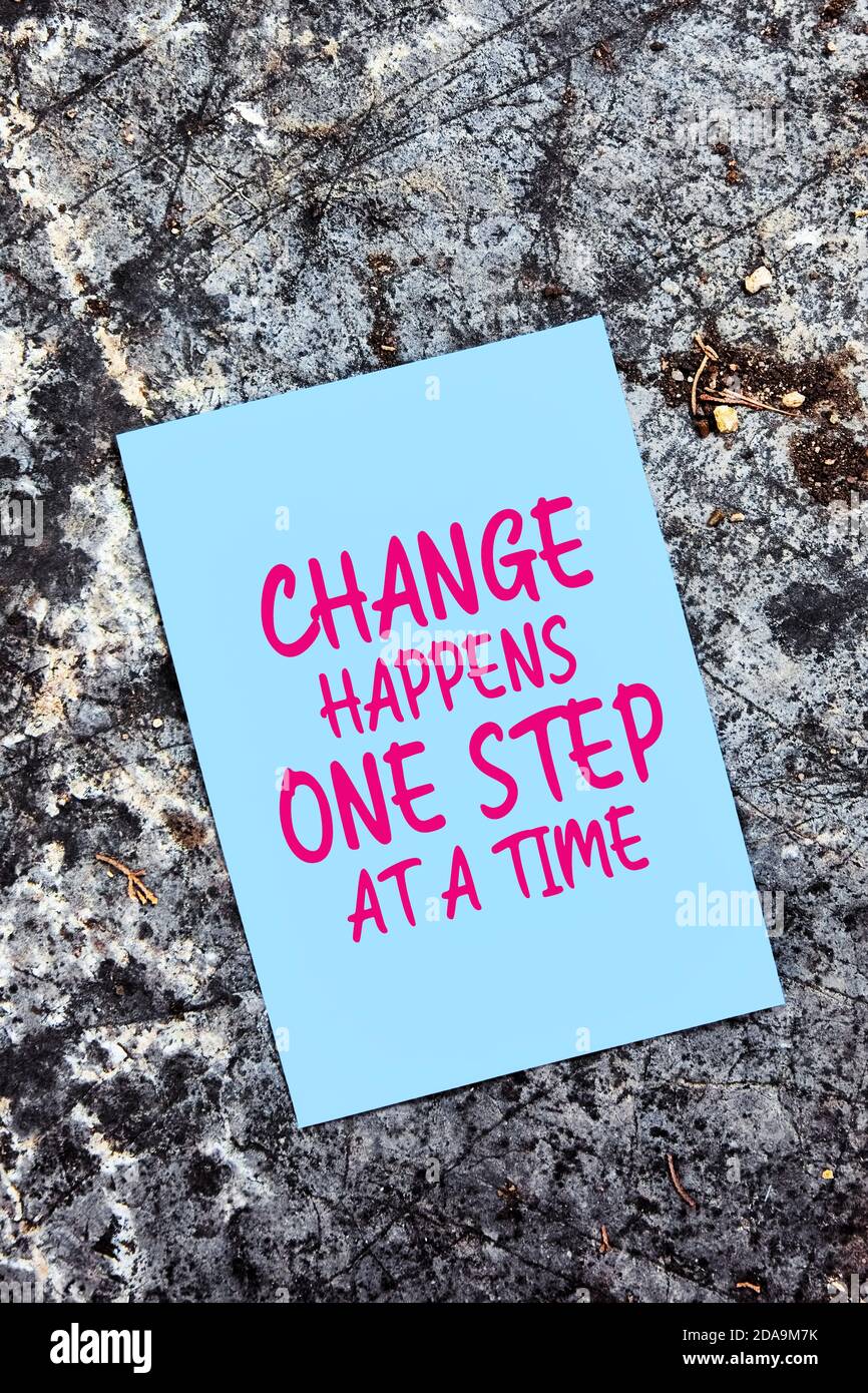 Change happens one step at at time quote written on paper on rock or ...