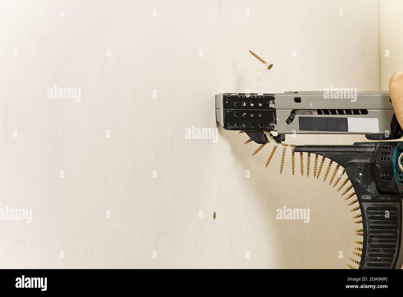 Room repair. Building. Worker fastens drywall with a screwdriver close ...