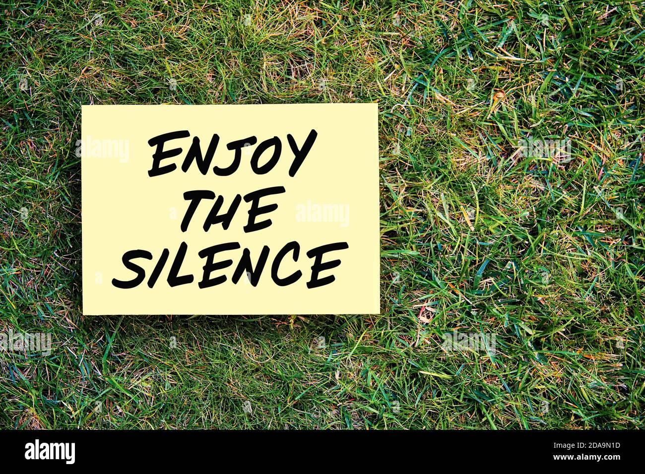 Enjoy the silence motivational message written on paper on grass ...