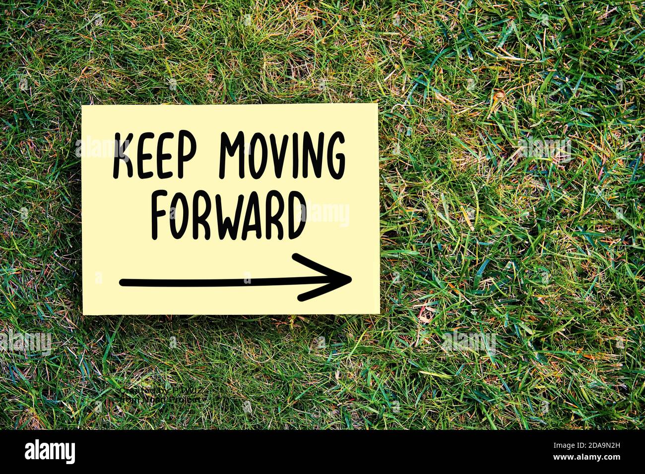 The words keep moving forward written on paper on green grass ...