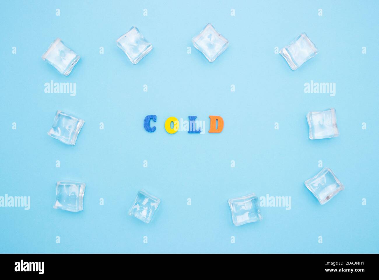 The word COLD on a blue background of wooden multicolored letters, ice ...