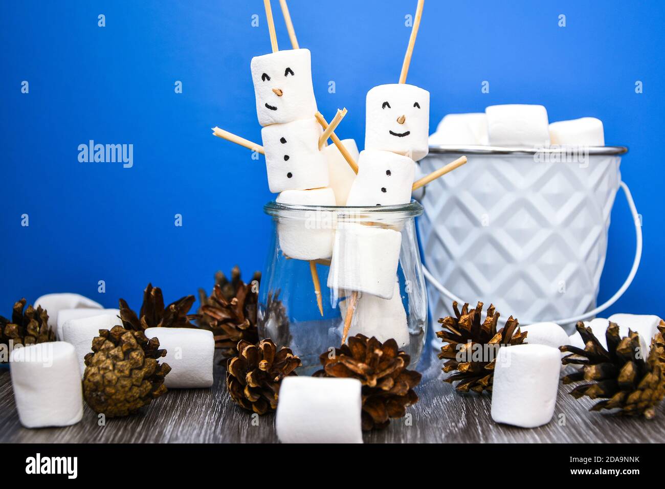 Two happy funny marshmallow snowmen. Marshmallow friends on blue ...