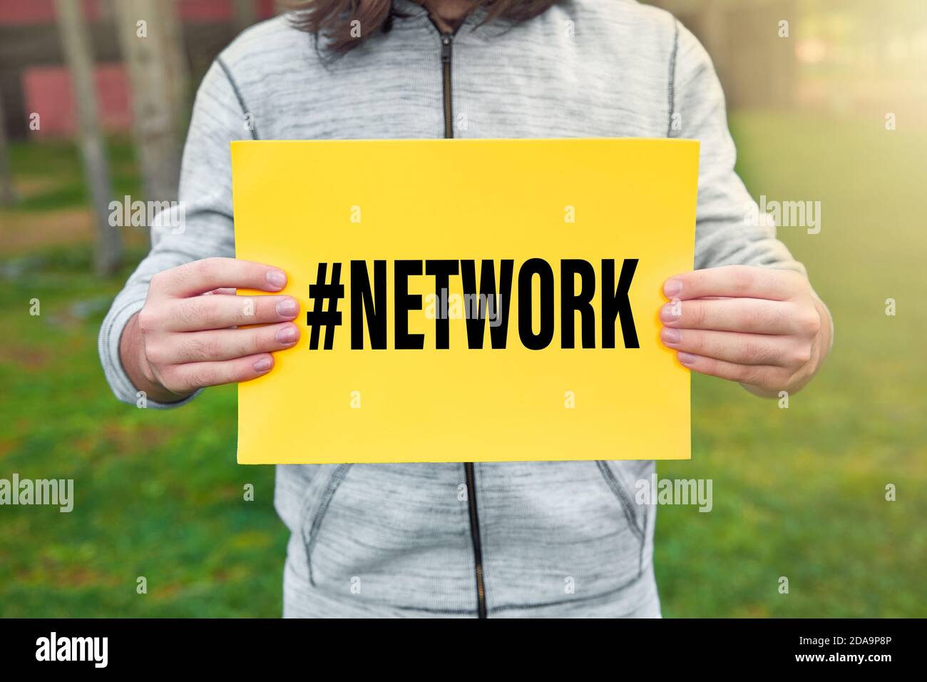 Male teenager holds a yellow banner with hashtag network message ...