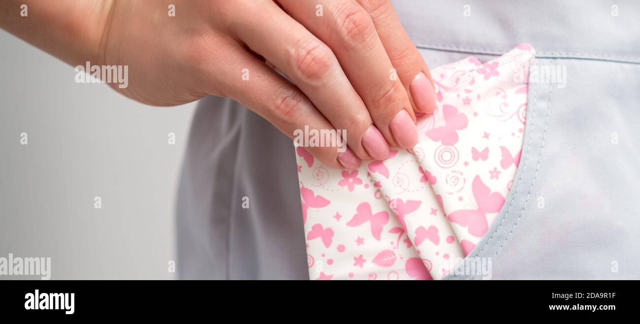 Close up of female hand puts menstrual sanitary pads into her pocket ...