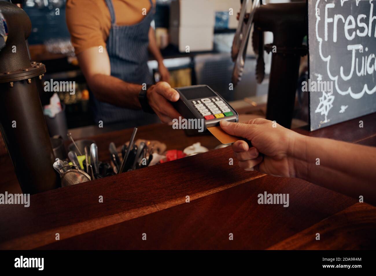 Close up of card payment being made between customer and bartender in ...