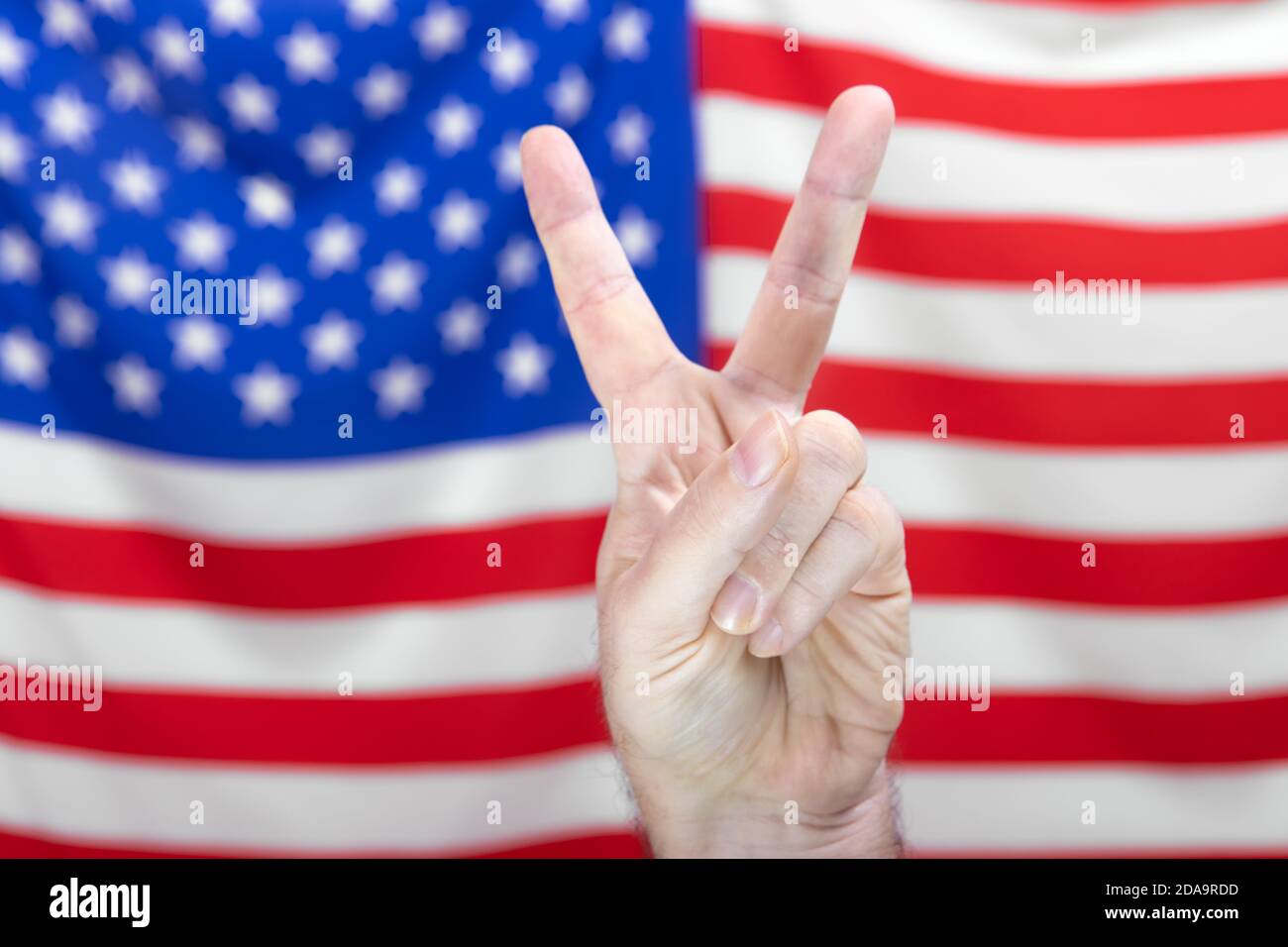 A hand shows fingers the symbol V, the gesture of victory in front of ...