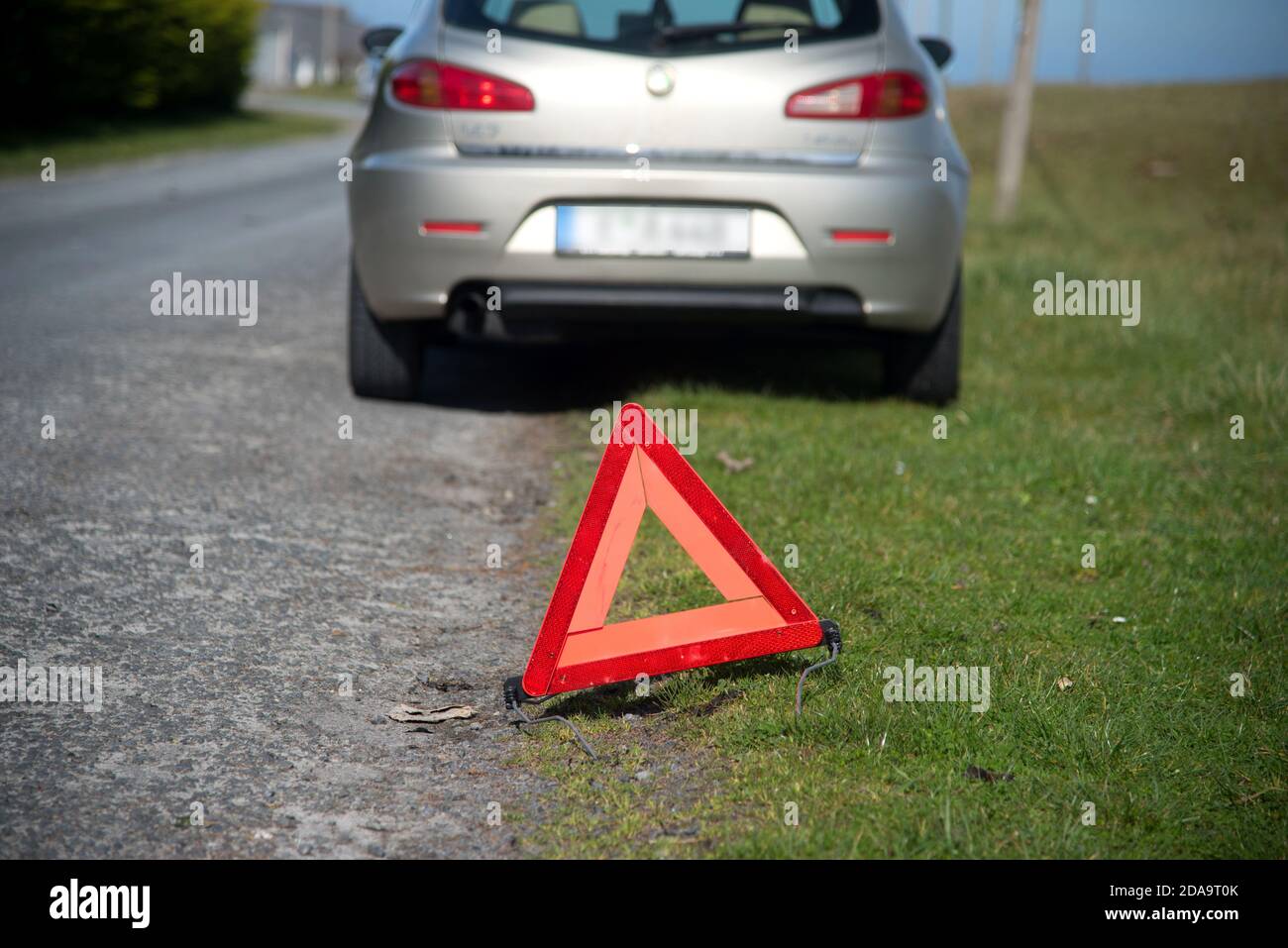 A broken down car and a warning triangle Stock Photo - Alamy