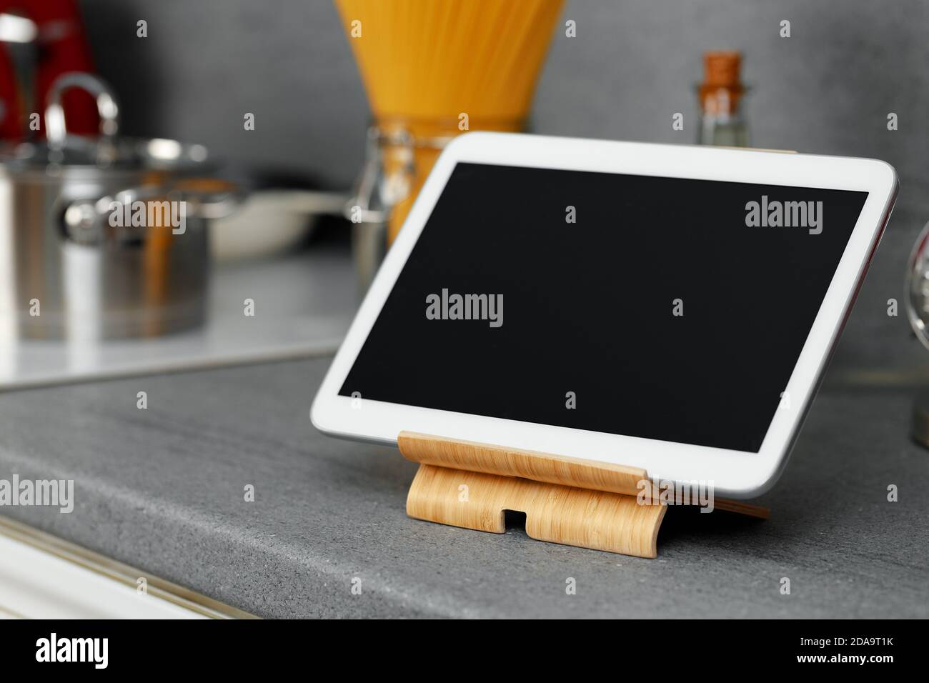 Digital tablet on wooden stand on kitchen counter Stock Photo - Alamy