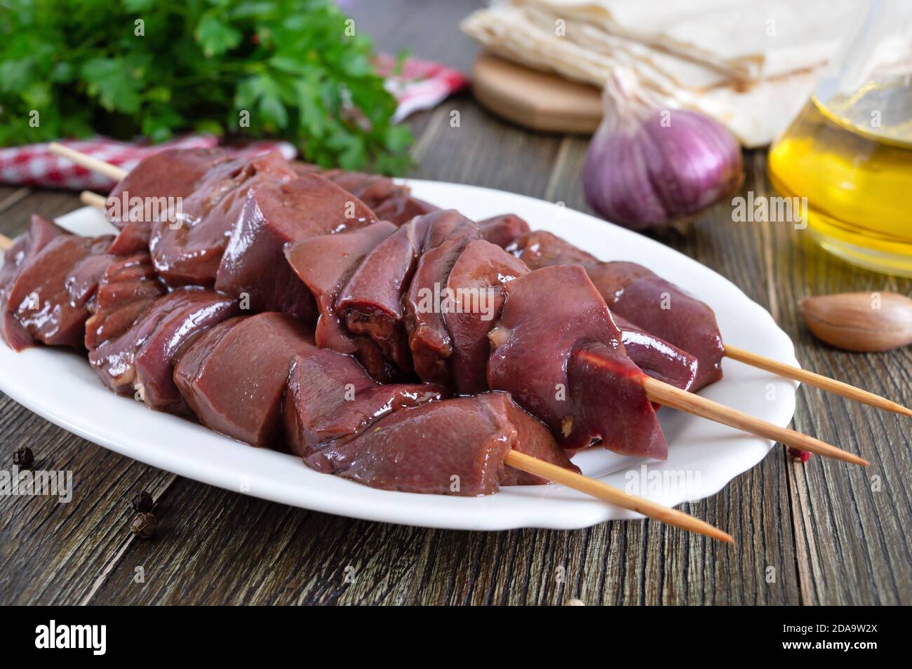 Pieces of raw pork liver on wooden skewers for cooking barbecue. Diet ...