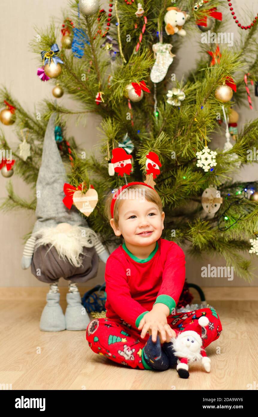 happy little boy sitting under the christmas tree Stock Photo - Alamy