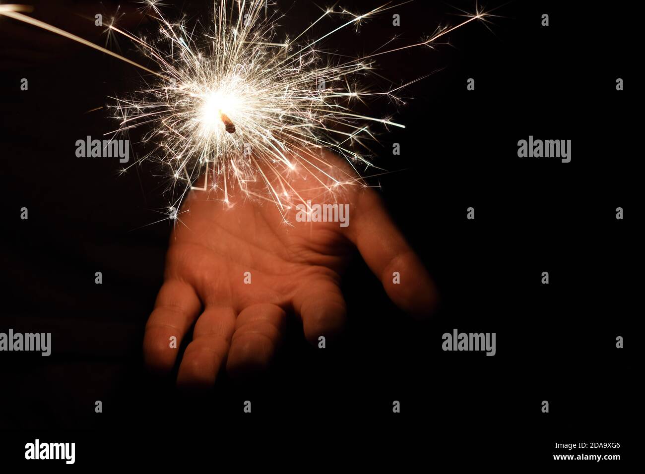 Hand with sparklers in a dark background Stock Photo - Alamy