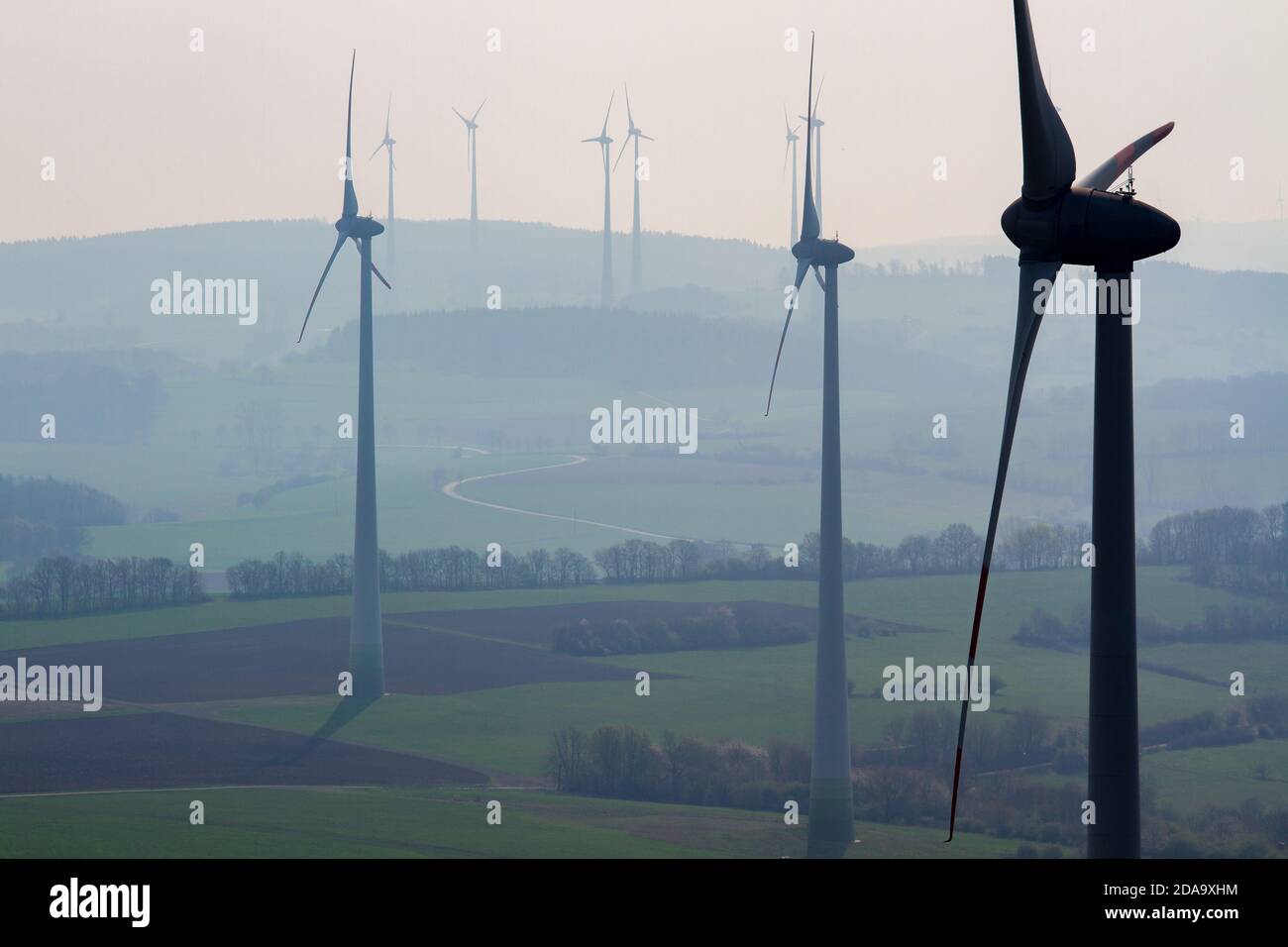 wind turbine, wind farm on a sunny misty morning shot from eye level ...