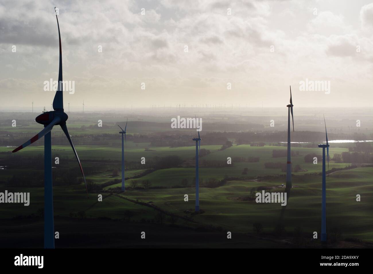 wind turbine, wind farm on a sunny misty morning shot from eye level ...
