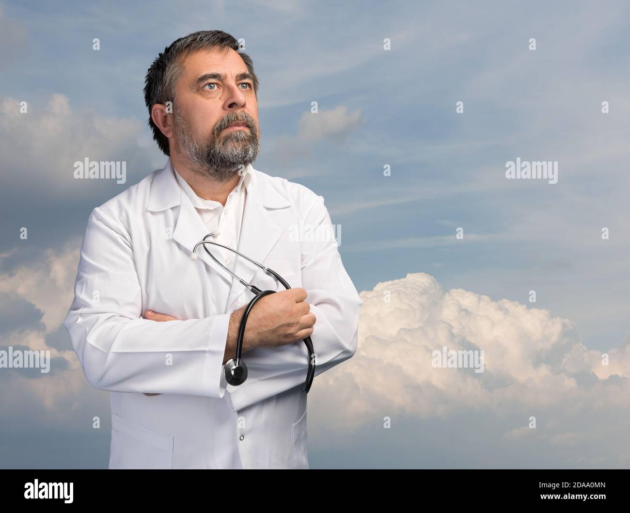 Portrait of a medical doctor with stethoscope against the blue sky with ...