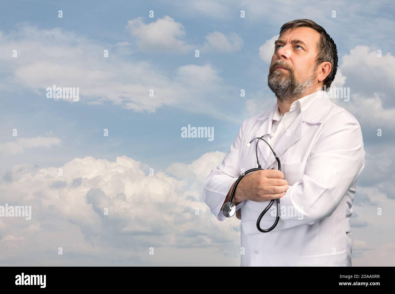 Portrait of a medical doctor with stethoscope against the blue sky with ...