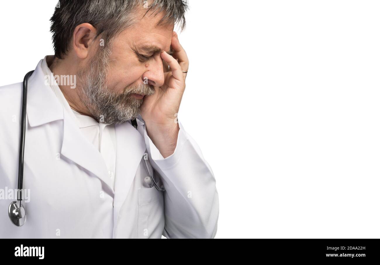 Portrait of a tired doctor with hand near his head, looking totally ...