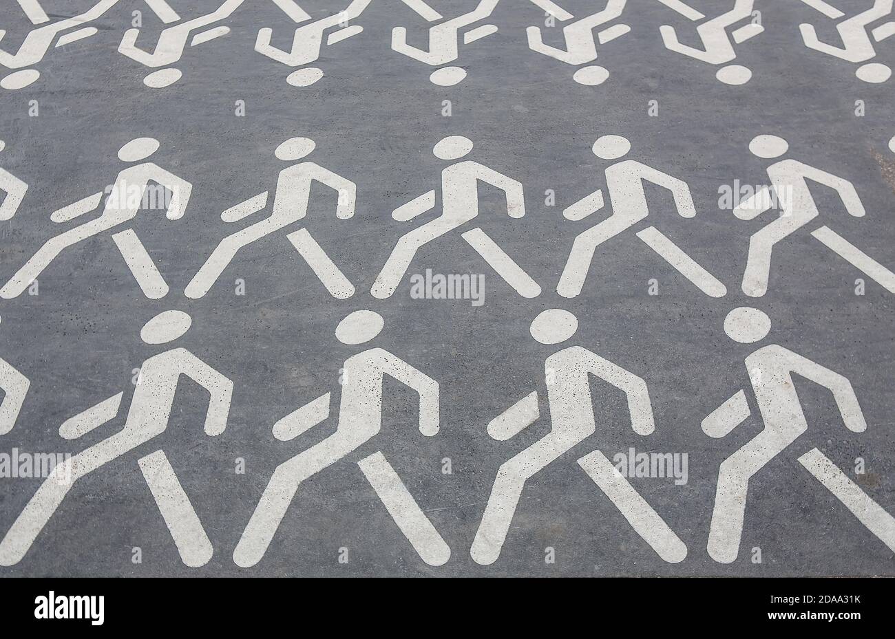 white pictograms of people walking in rows on the asphalt Stock Photo ...