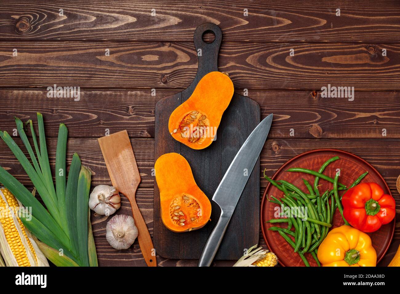 Small pumpkin cut into halves on wooden cutting board with knife Stock ...