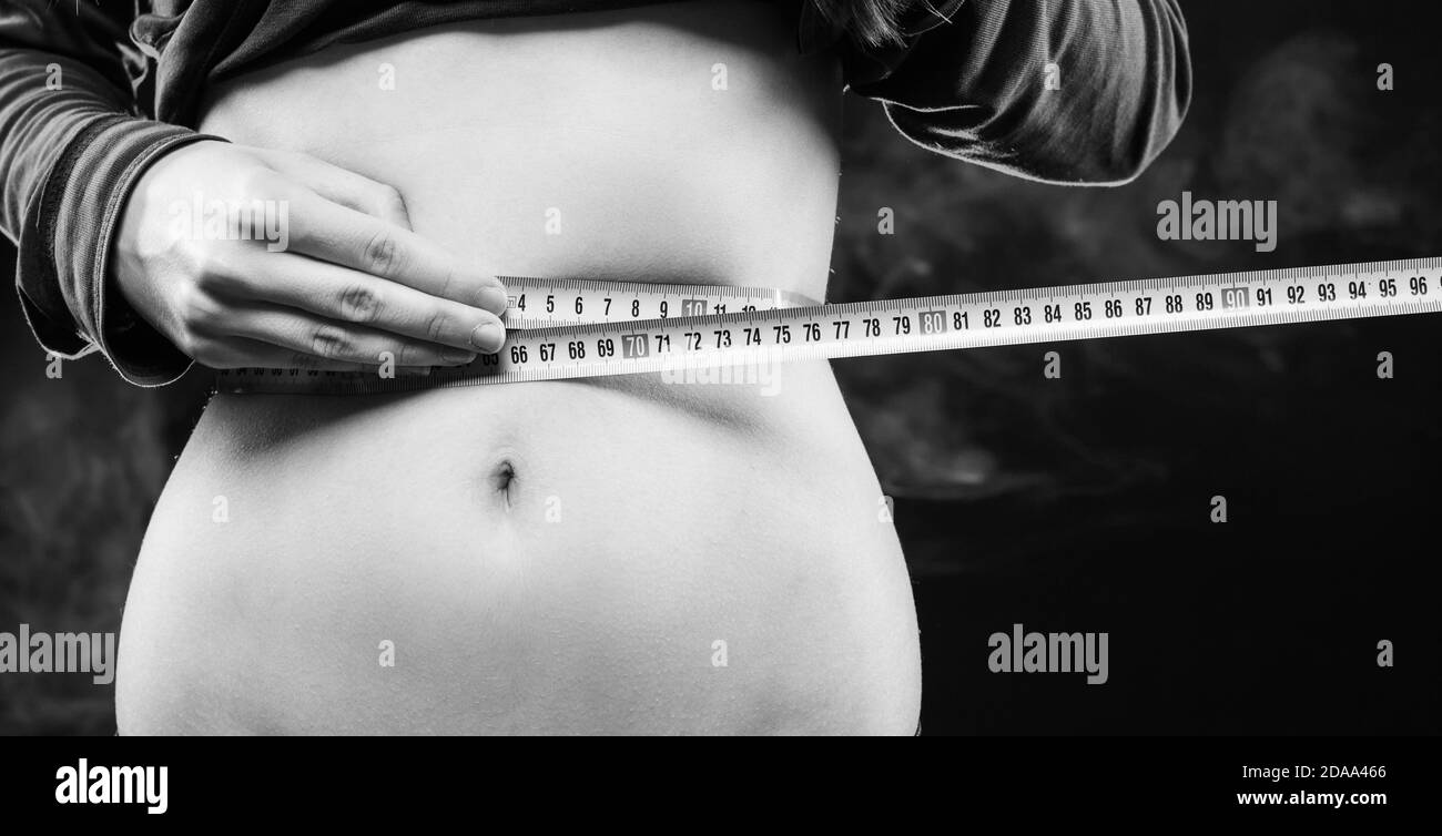 A Young Woman Measures The Size Of Her Waist With A Measuring Tape