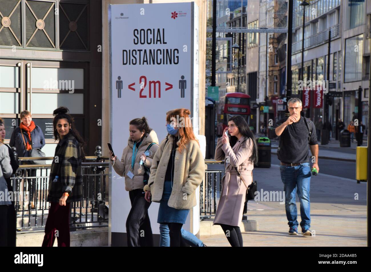 People walk past a Social Distancing sign on Oxford Street, London ...