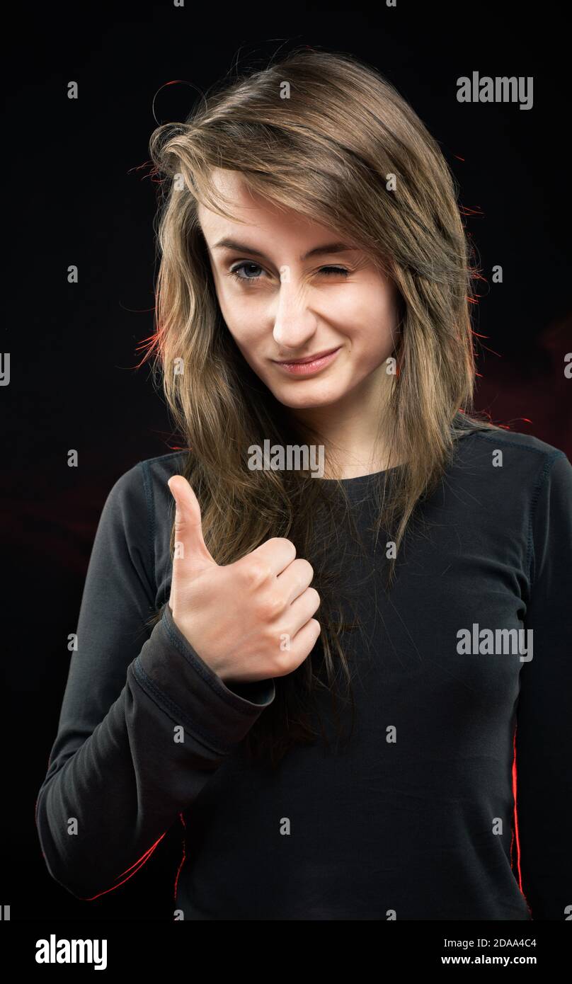Teenage girl squinting with one eye and shows the symbol OK. Fashion ...