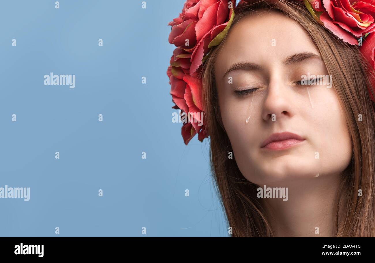 Close-up portrait of beautiful crying girl with tears on her cheeks and ...