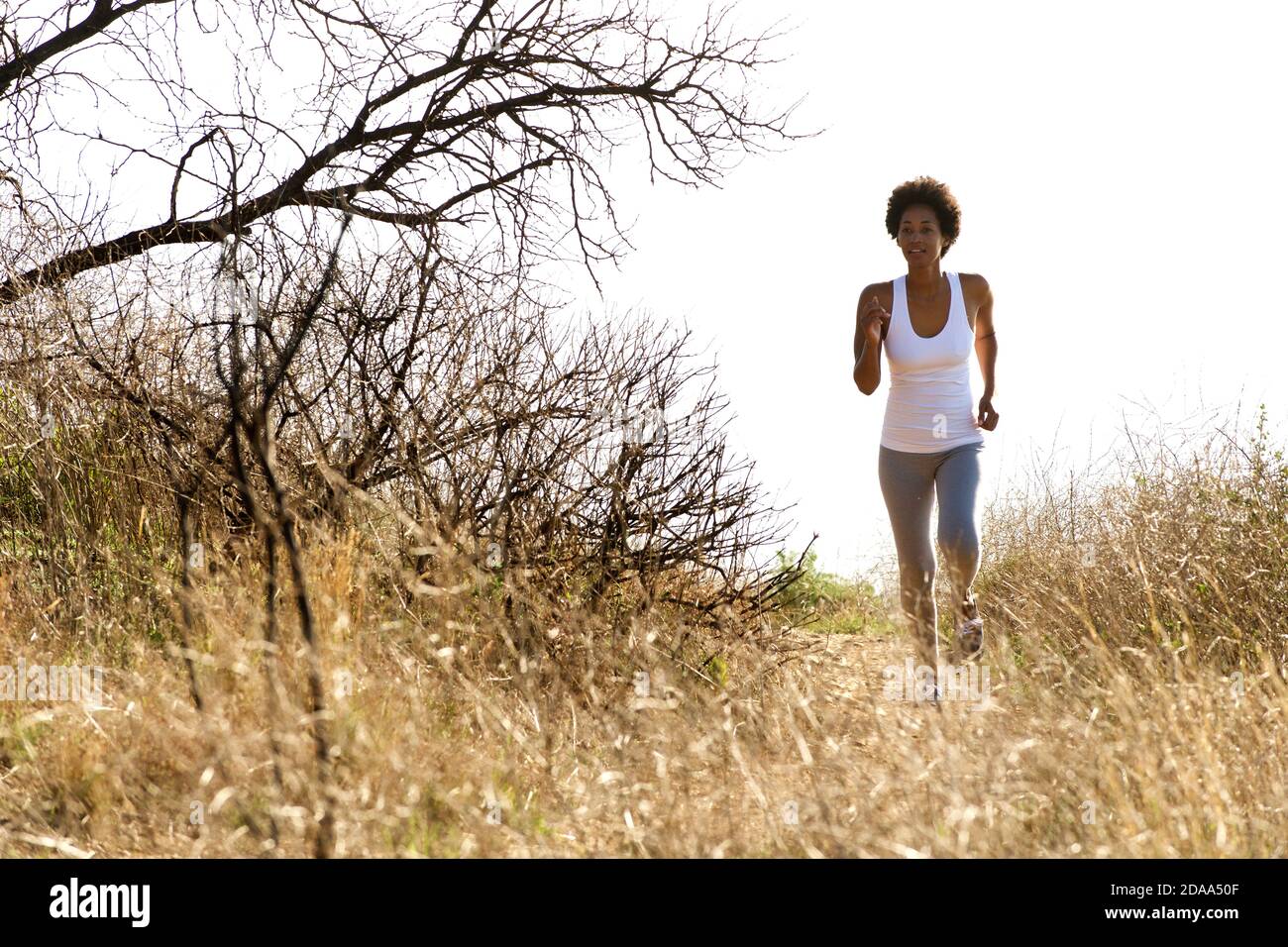 Portrait of healthy young african woman running on mountain trail Stock ...