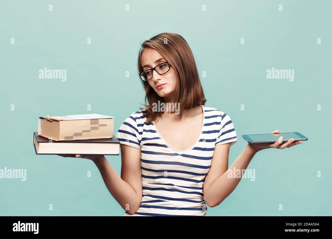 Book vs e-book. Girl student holding traditional textbook and ebook ...