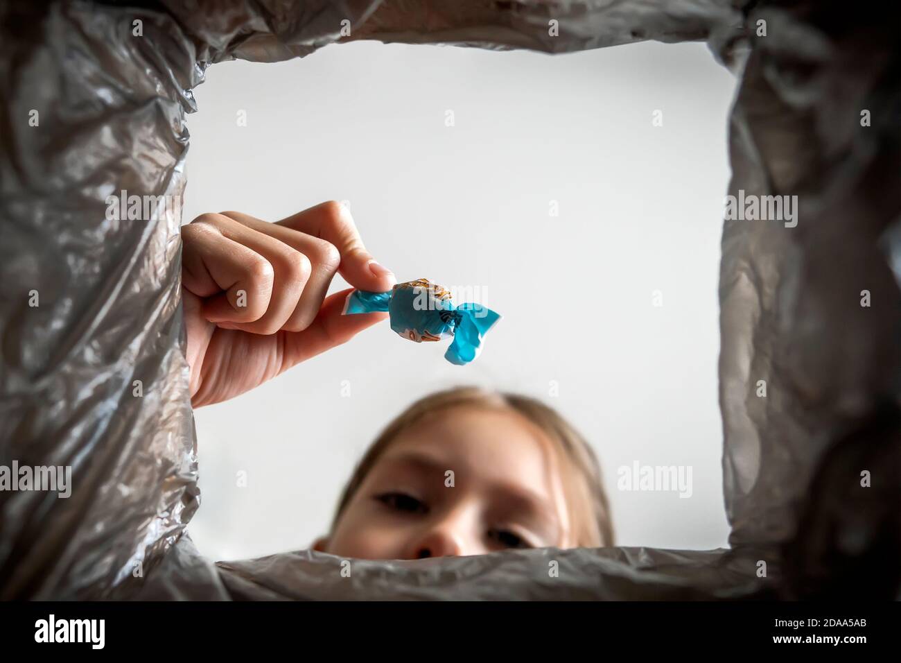 Girl throws sweet candy in the trash. refusal of sweets Stock Photo - Alamy