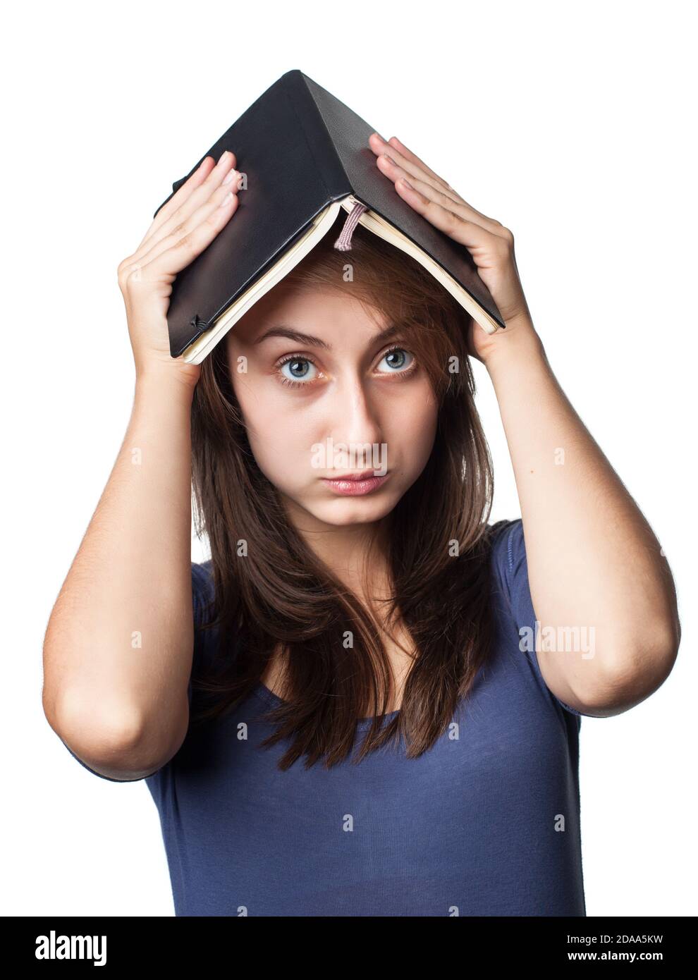 Education. Tired girl holds a notebook on her head on a white ...