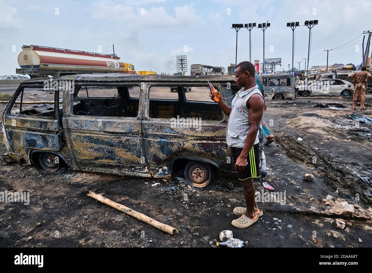 A man taking photographs of damaged vehicles at a site following an ...