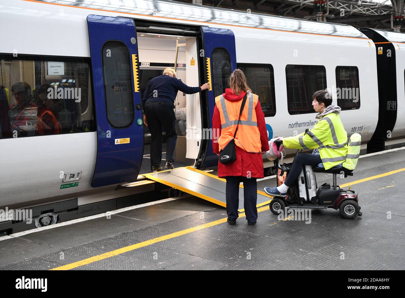 Train and station staff at Preston railway station help a disabled ...