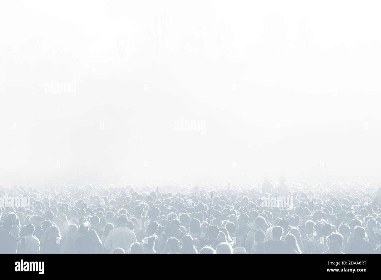 Crowd of spectators at a concert in light blue tonality. High key ...