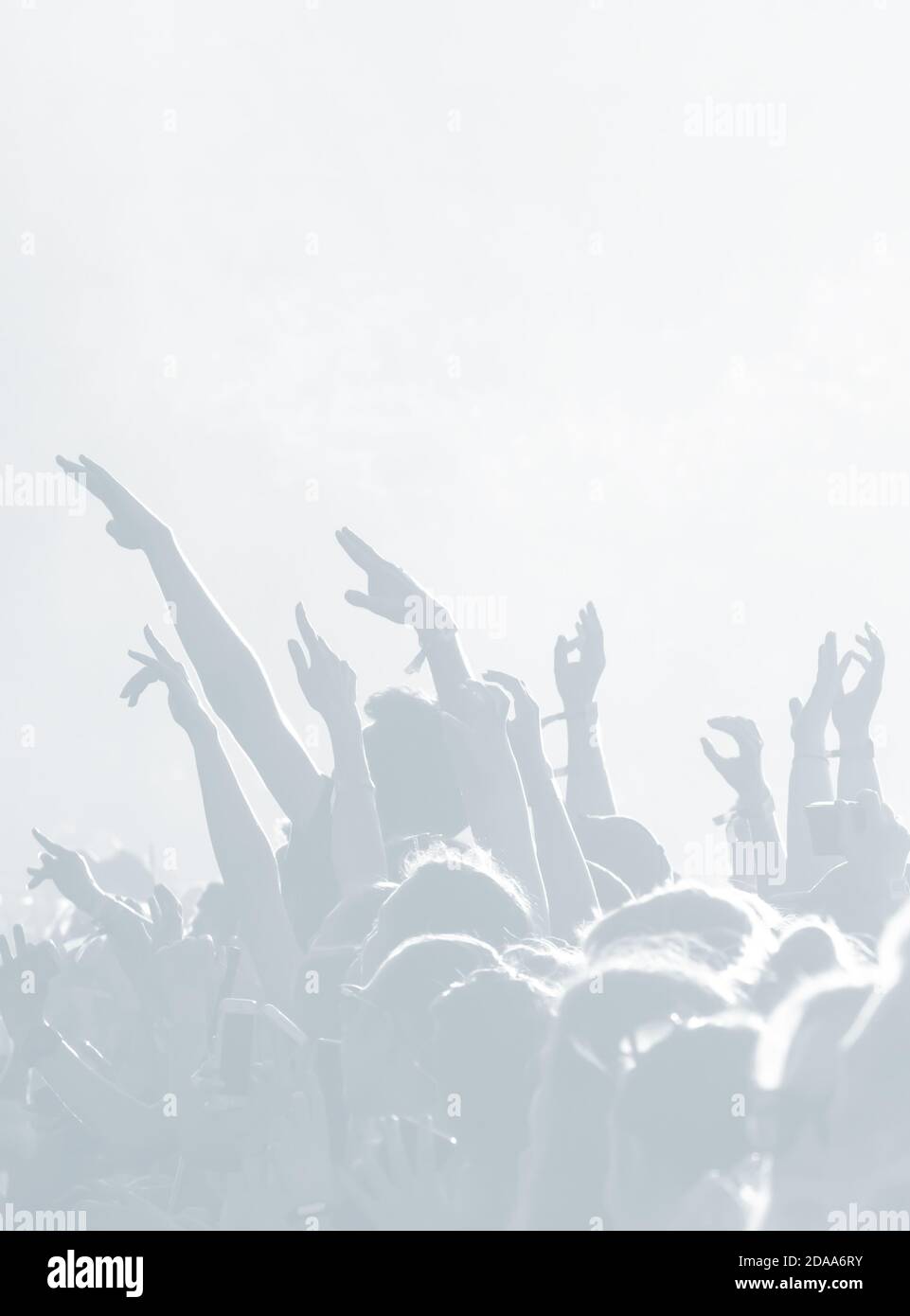 Crowd of spectators at a concert in light blue tonality. High key ...