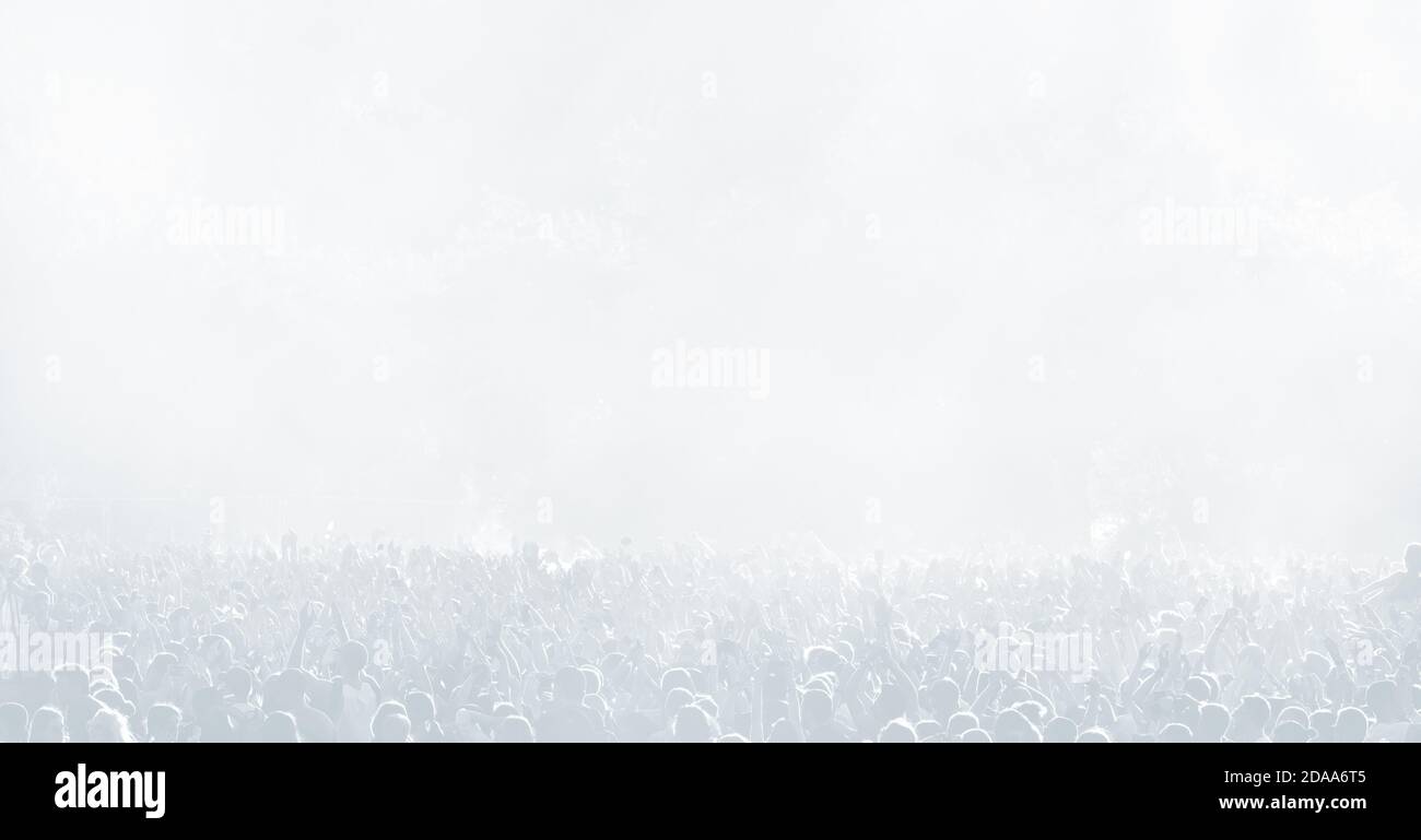 Crowd of spectators at a concert in light blue tonality. High key ...