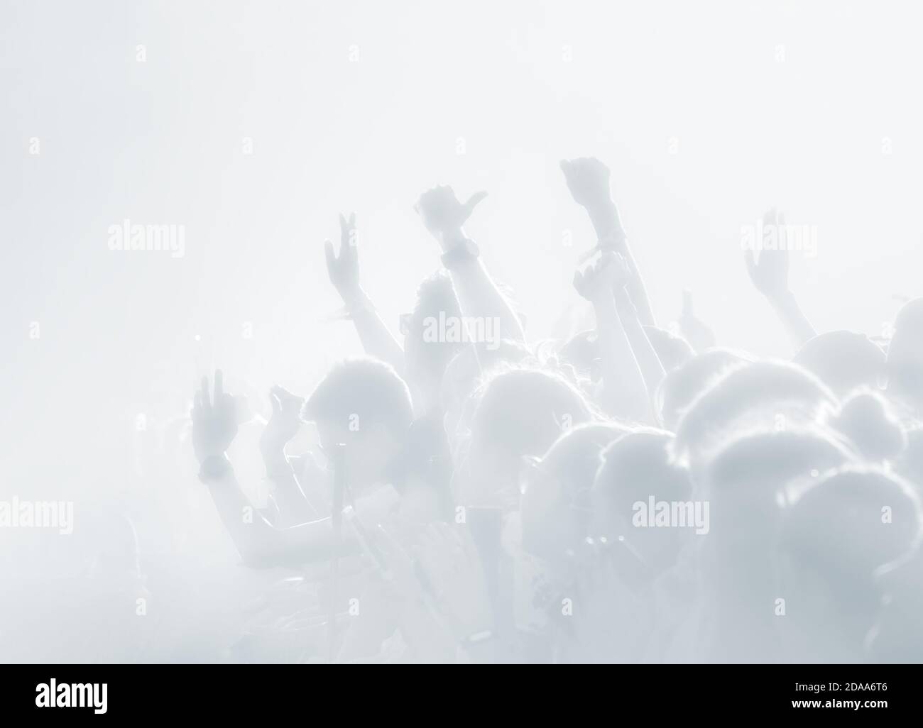 Crowd of spectators at a concert in light blue tonality. High key ...