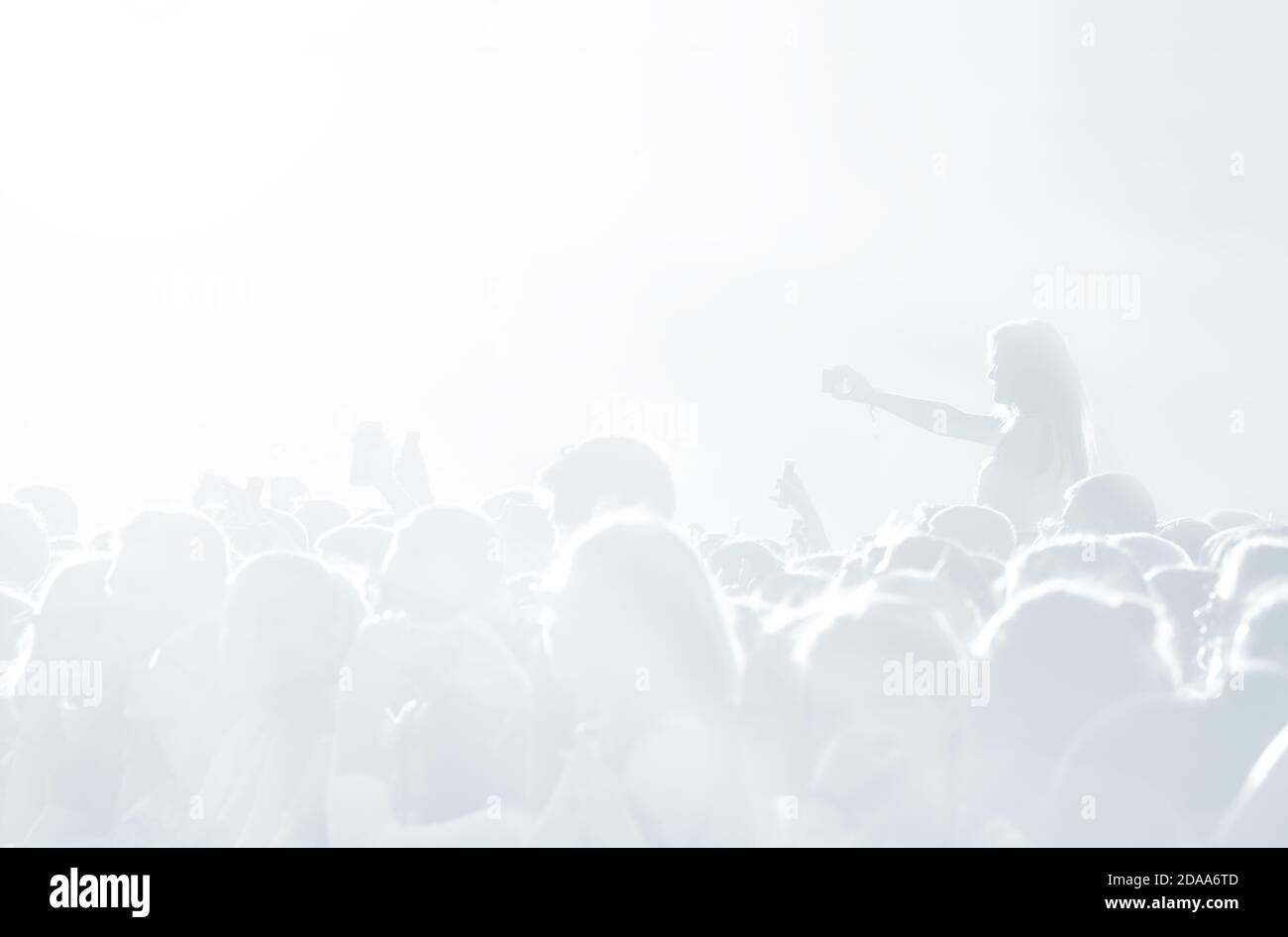 Crowd of spectators at a concert in light blue tonality. High key ...