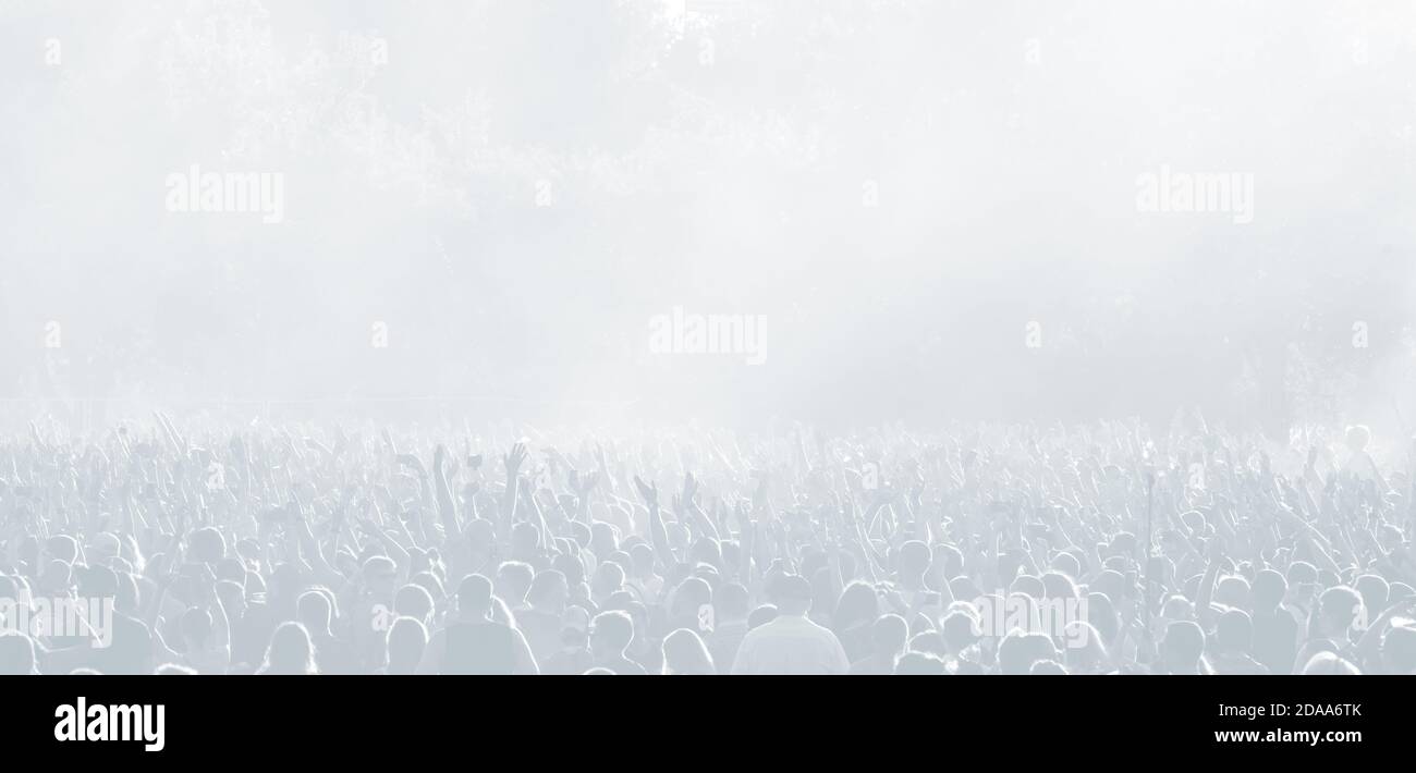 Crowd of spectators at a concert in light blue tonality. High key ...