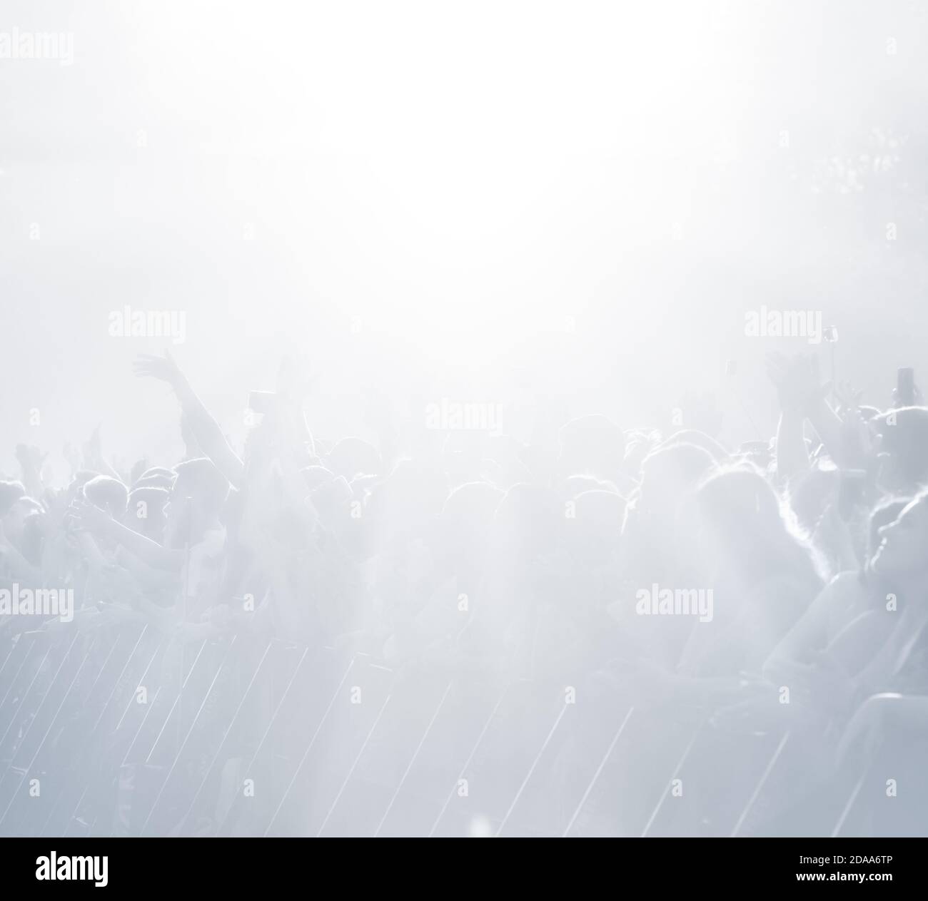 Crowd of spectators at a concert in light blue tonality. High key ...