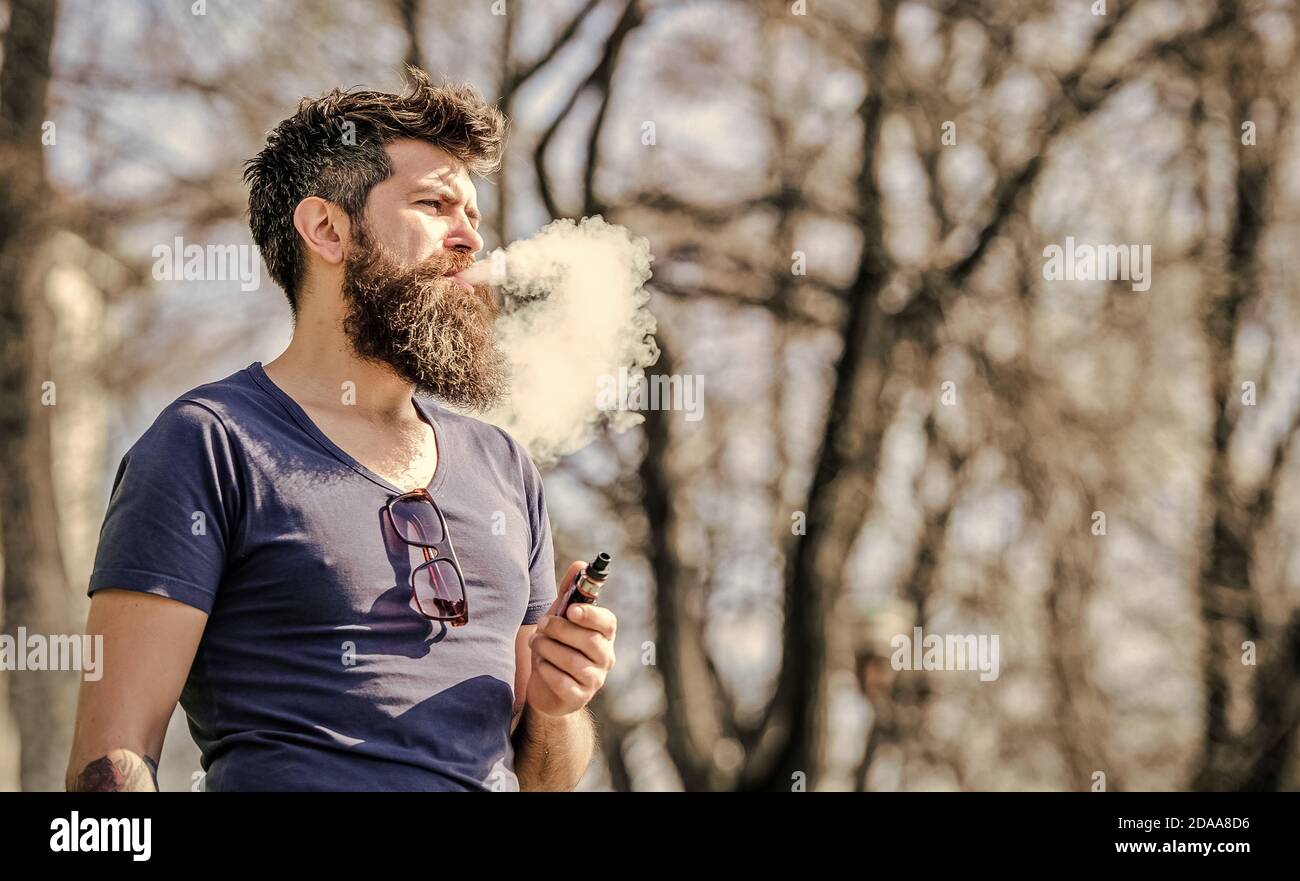 Stress relief concept. Bearded man smoking vape. White clouds of ...