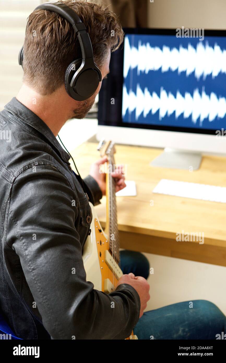 Portrait from behind of musician recording electric guitar Stock Photo ...