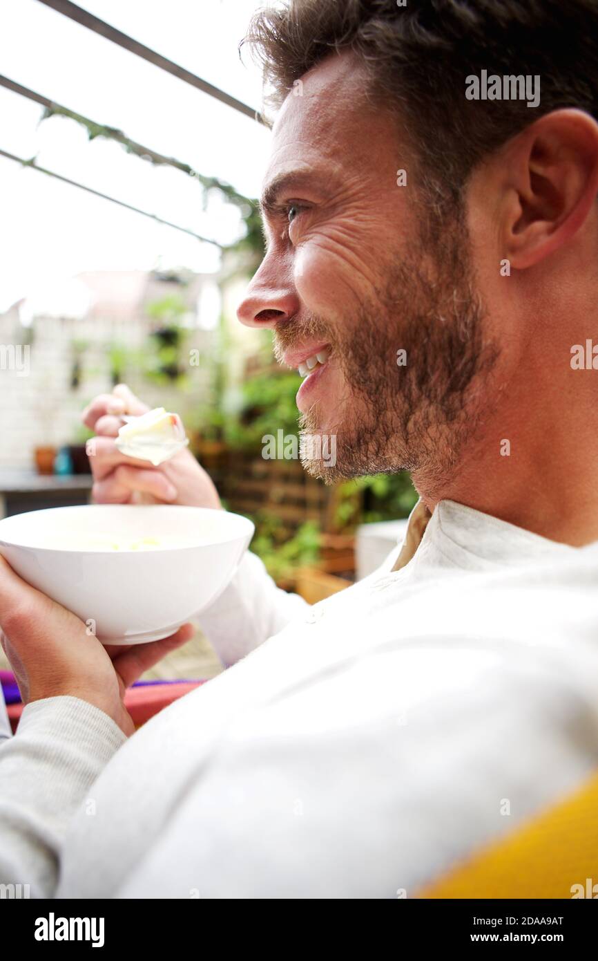 Close up side profile portrait of cheerful older man eating healthy ...