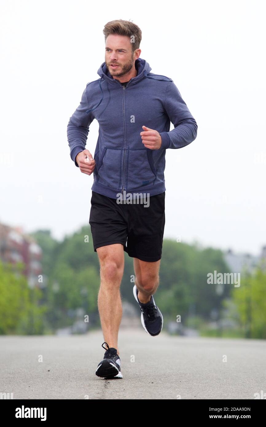 Full length portrait of middle age athlete running outside Stock Photo ...