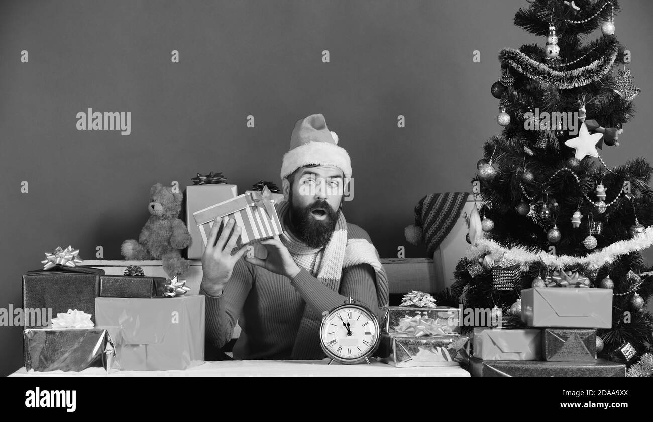 Santa holds gift box. Santa Claus holds presents near decorated tree on ...