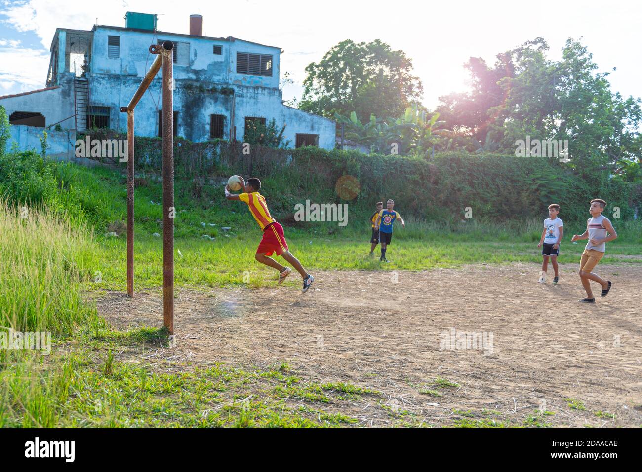 Cuban young people playing soccer or football in an abandoned field ...